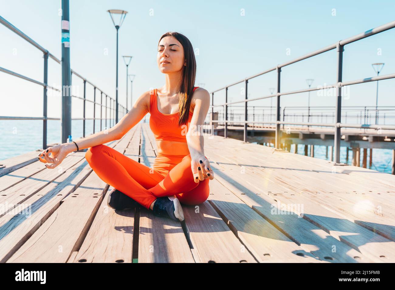 Woman relaxing in yoga position in the summer in front of the sea Stock ...