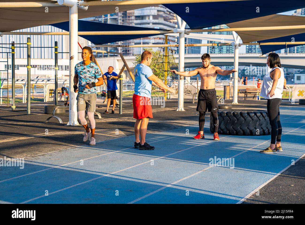 Fitness instructor training men and women at outdoor health club Stock ...