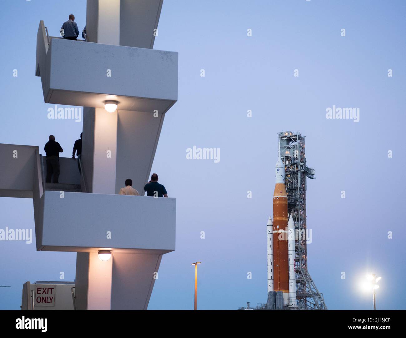 NASA employees are seen on the stairs outside of the Rocco A. Petrone ...