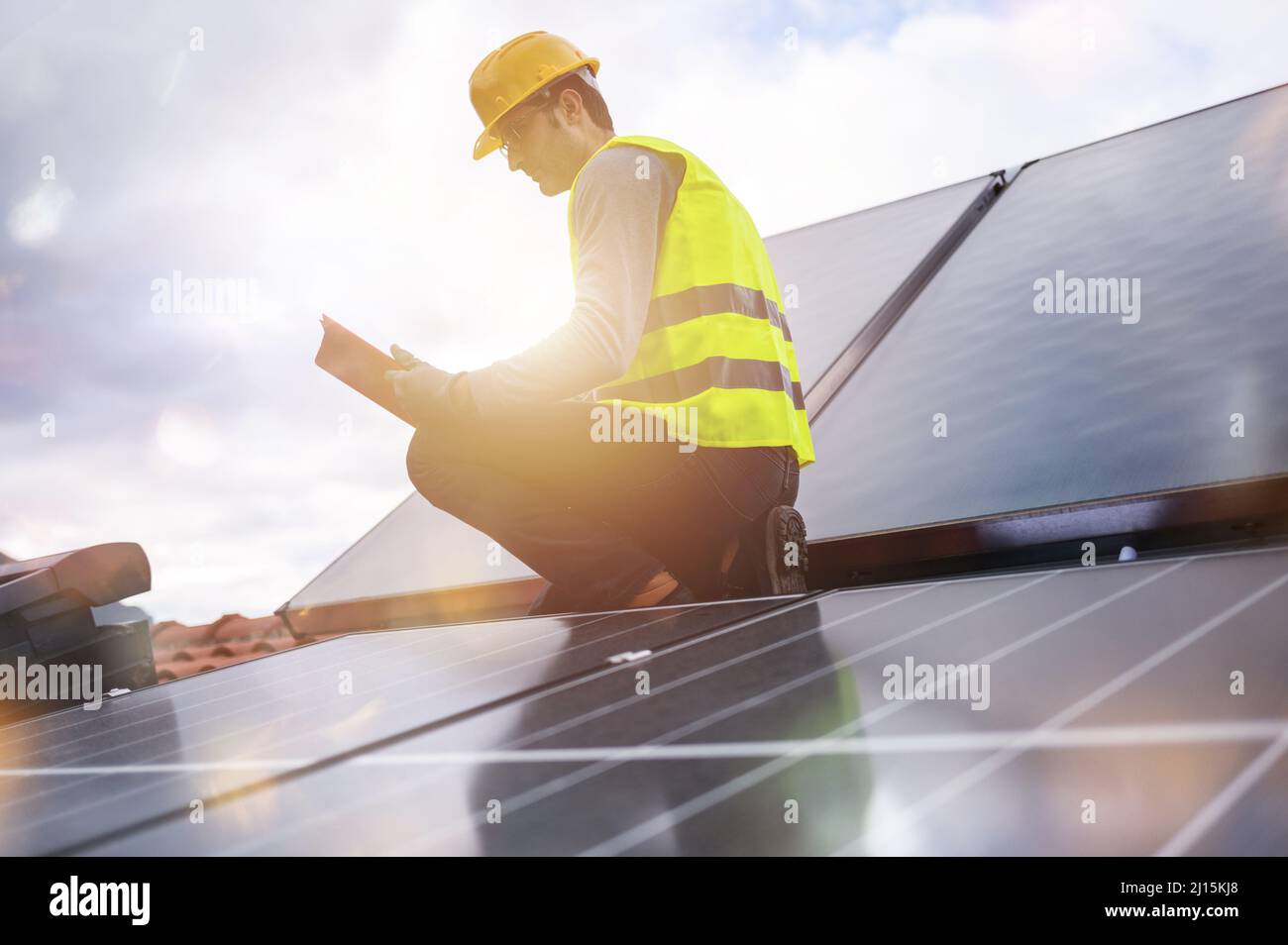 Man works on renewable energy system with solar panel for electricity ...