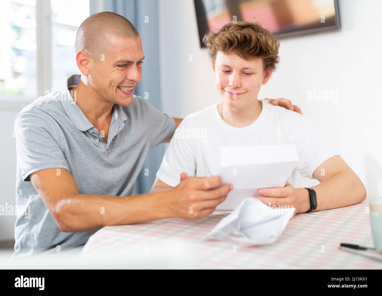 Father congratulates his son after reading letter from college Stock ...