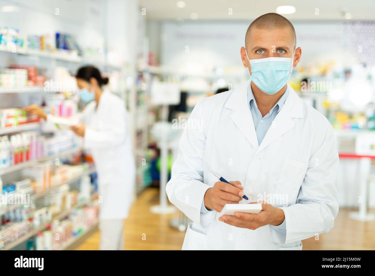 Doctor in face mask standing in chemist shop Stock Photo - Alamy