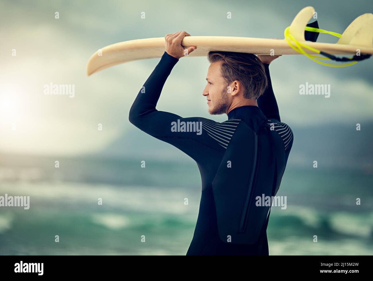 Just me and the big blue sea. Shot of a laid-back young surfer watching ...