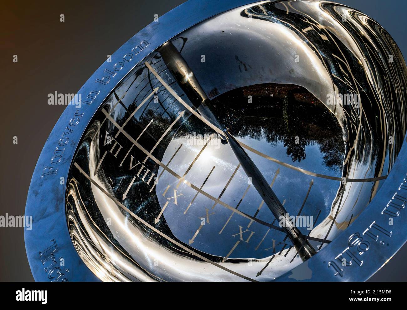 Shiny silver sun dial in a park garden Stock Photo - Alamy