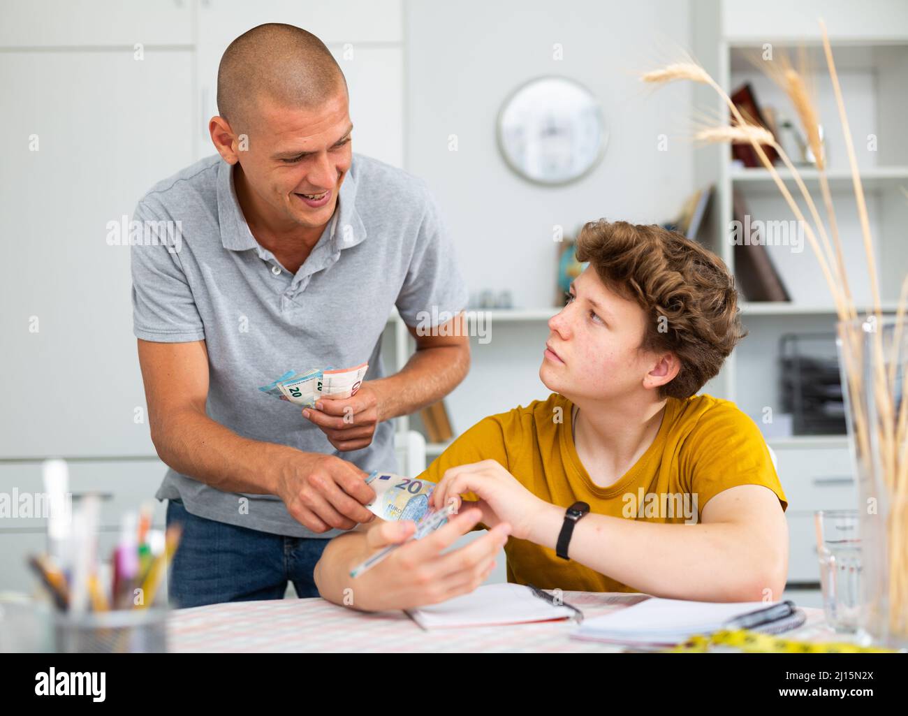 Father gives his son pocket money Stock Photo - Alamy
