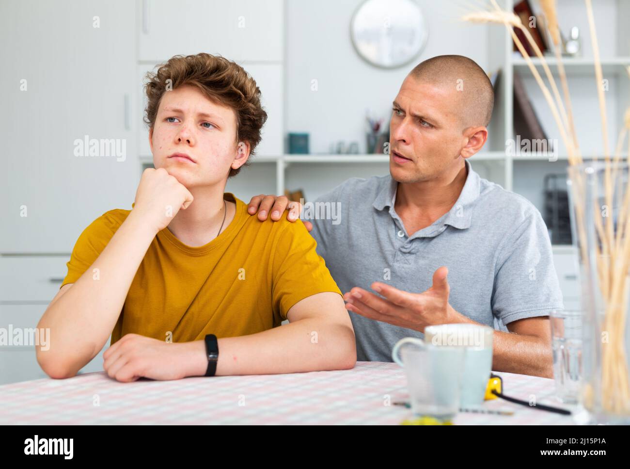 Teenager feeling upset and his father comforting him Stock Photo - Alamy