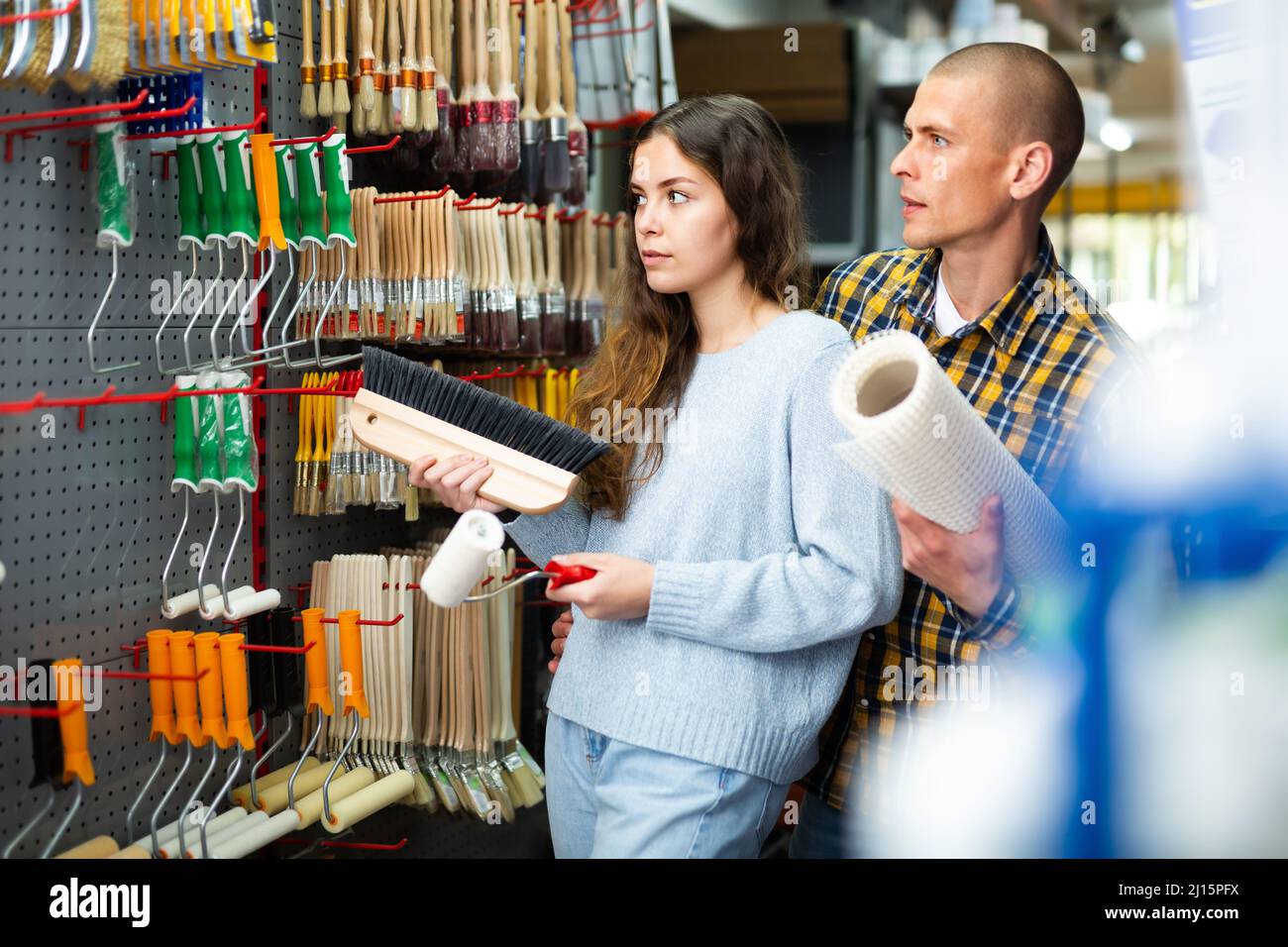 Man and woman are choosing different tools in hardware store Stock ...