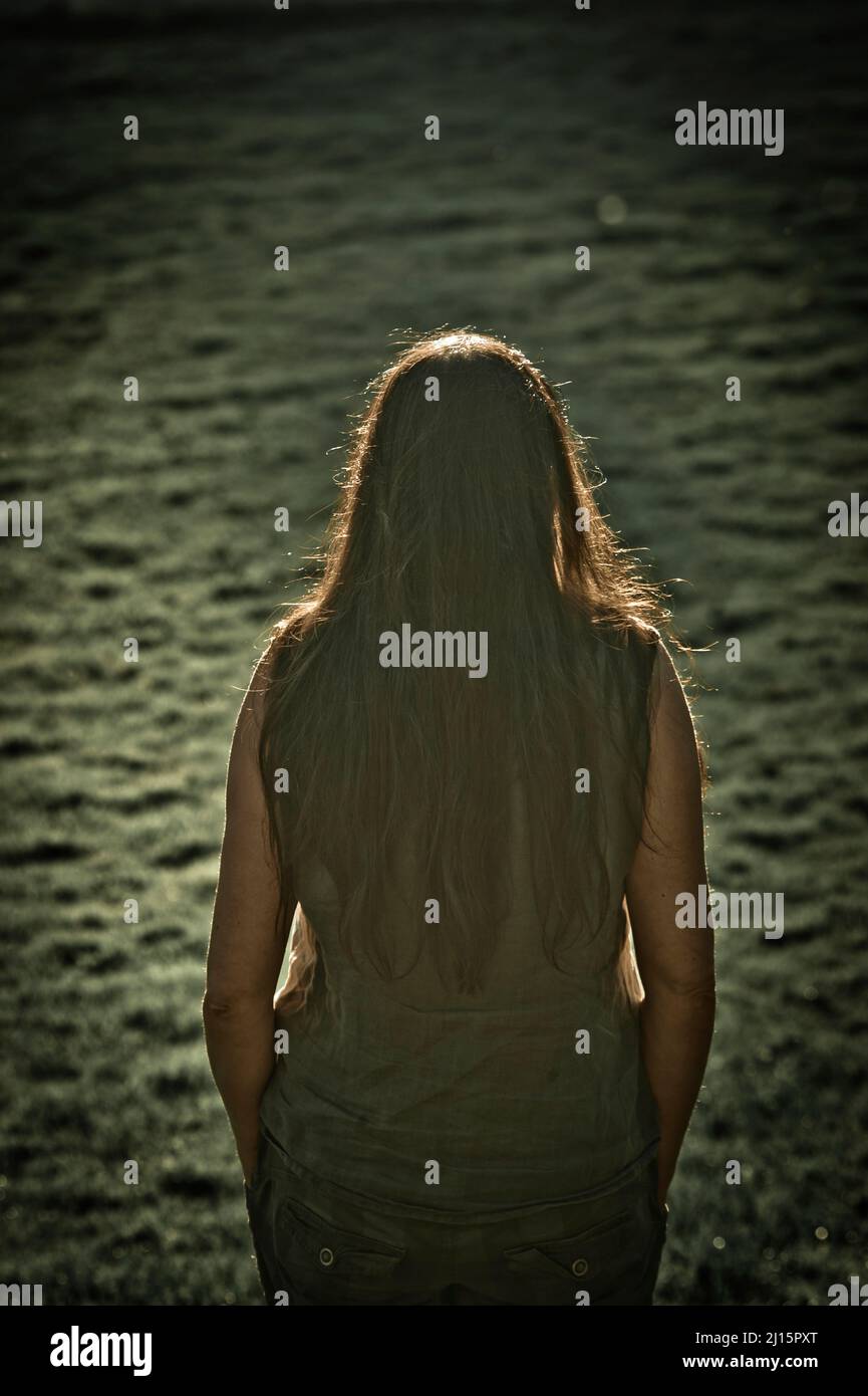 back of head and shoulders of a woman with dark long hair Stock Photo ...