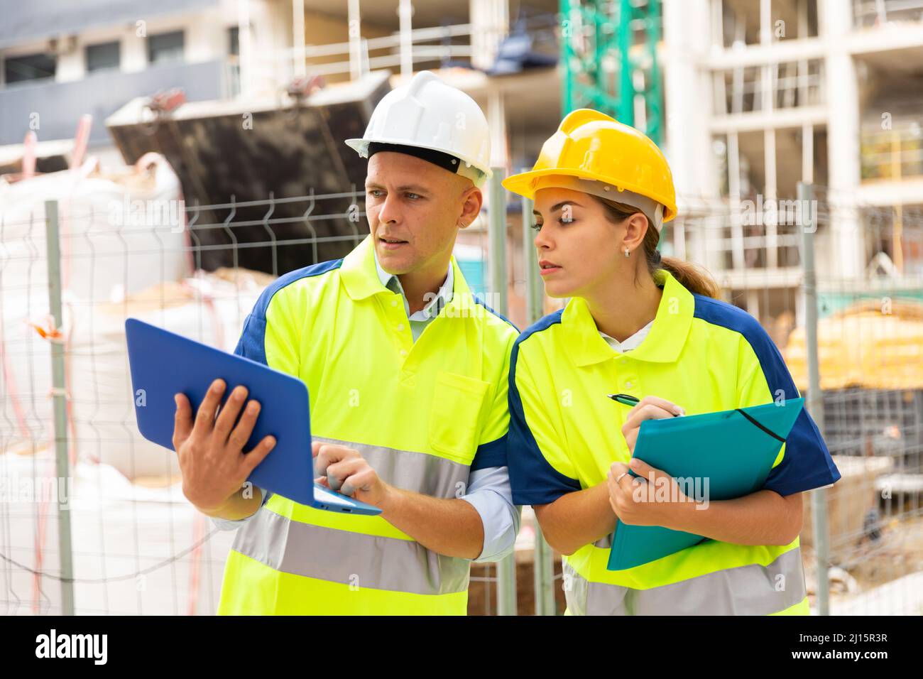 Male and female engineers in construction area Stock Photo - Alamy