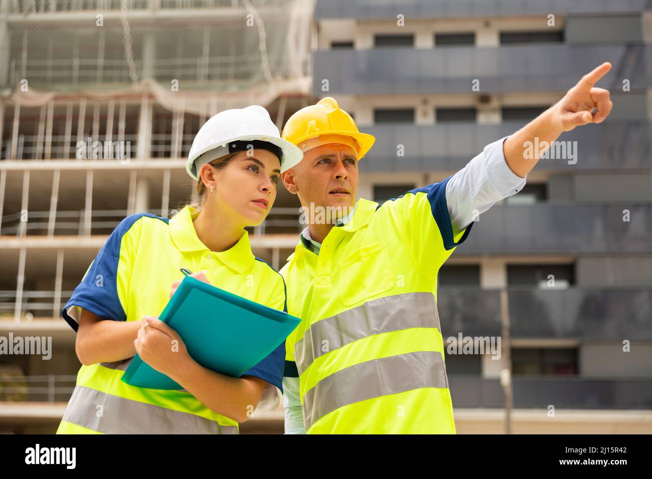 Male and female builders talking in construction site Stock Photo - Alamy