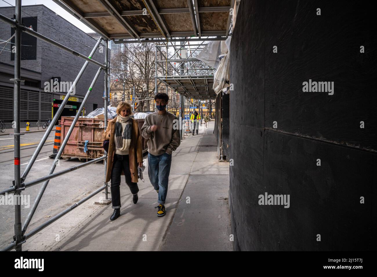 Toronto, Canada. 22nd Mar, 2022. Masked and unmasked people walk down ...