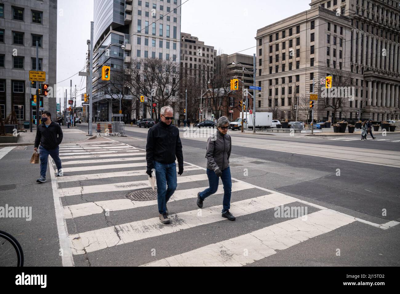 Toronto, Canada. 22nd Mar, 2022. Masked and unmasked pedestrians cross ...