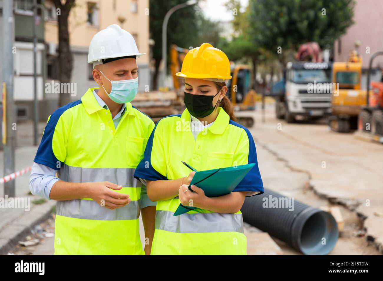 Civil engineers in masks checking work process Stock Photo - Alamy