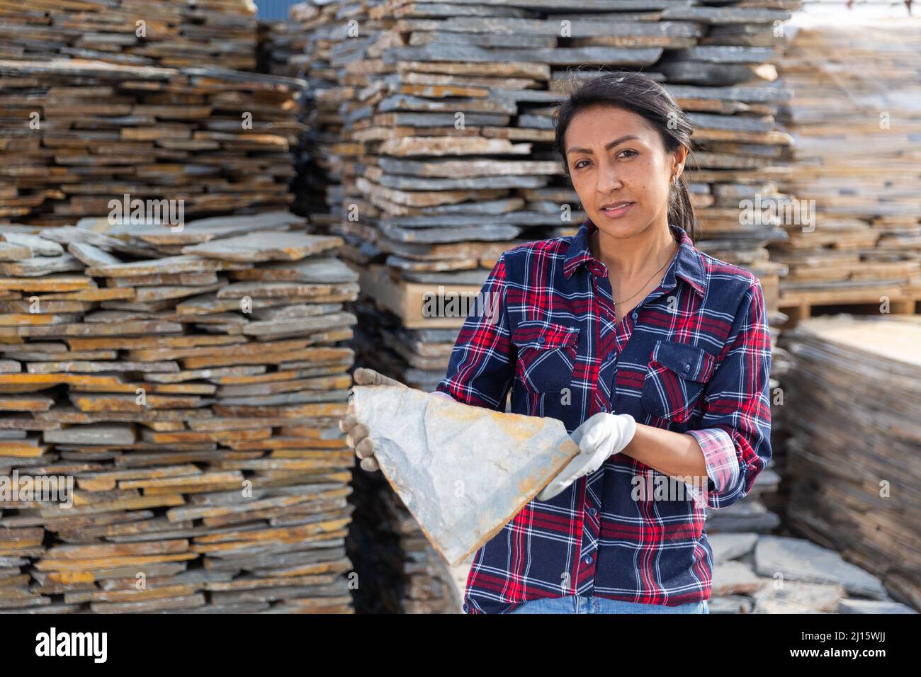 Hispanic woman worker posing with natural stone tile Stock Photo - Alamy
