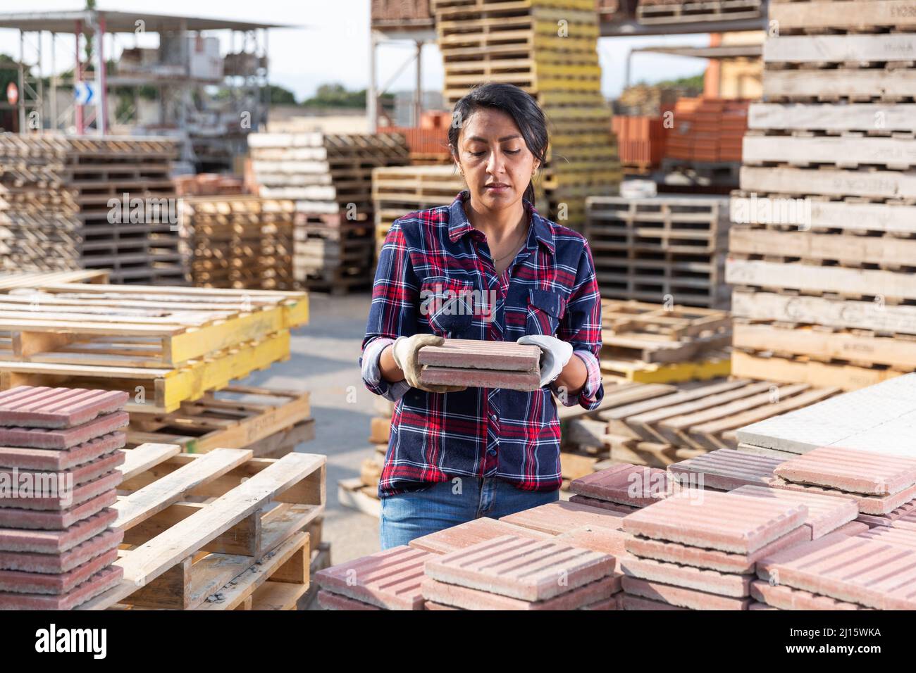 Latin american female stacking tiles on pallet Stock Photo - Alamy