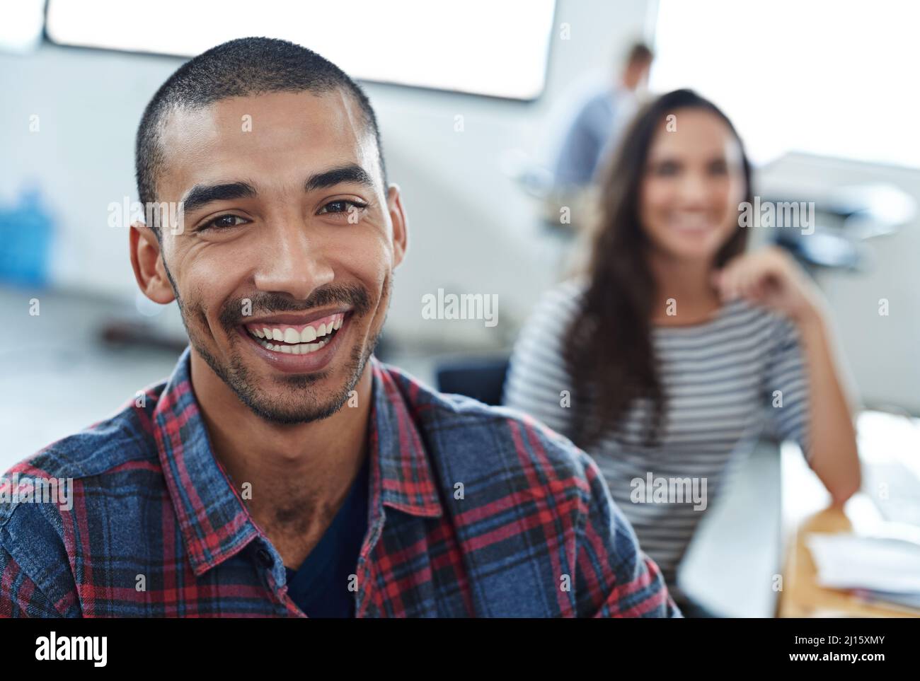 Make creativity a job. Portrait of two smiling coworkers sitting at ...