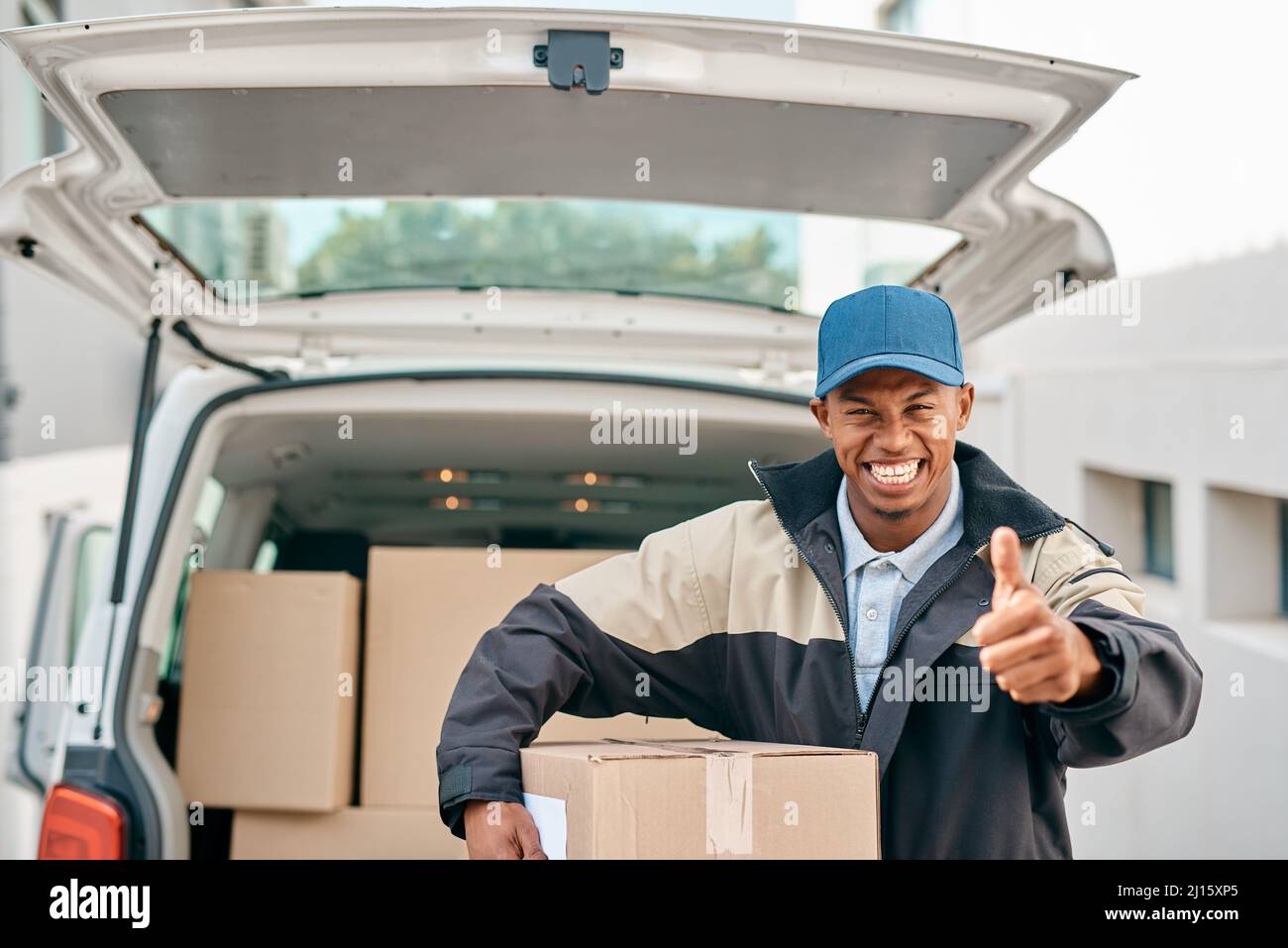 Its been a good day of deliveries. Portrait of a courier showing thumbs ...