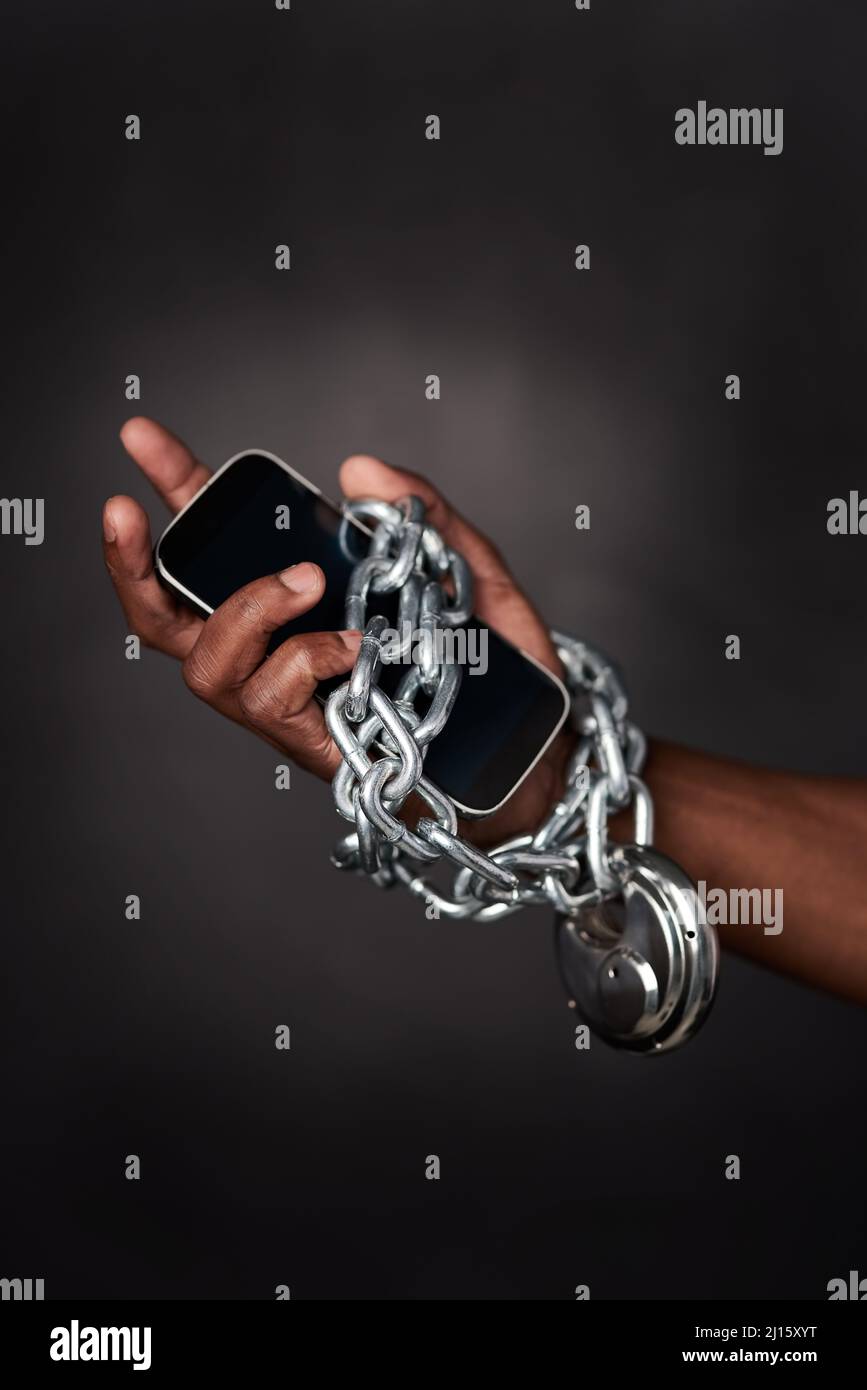 Tied to technology 247. Cropped shot of a mans phone tied to his hand ...