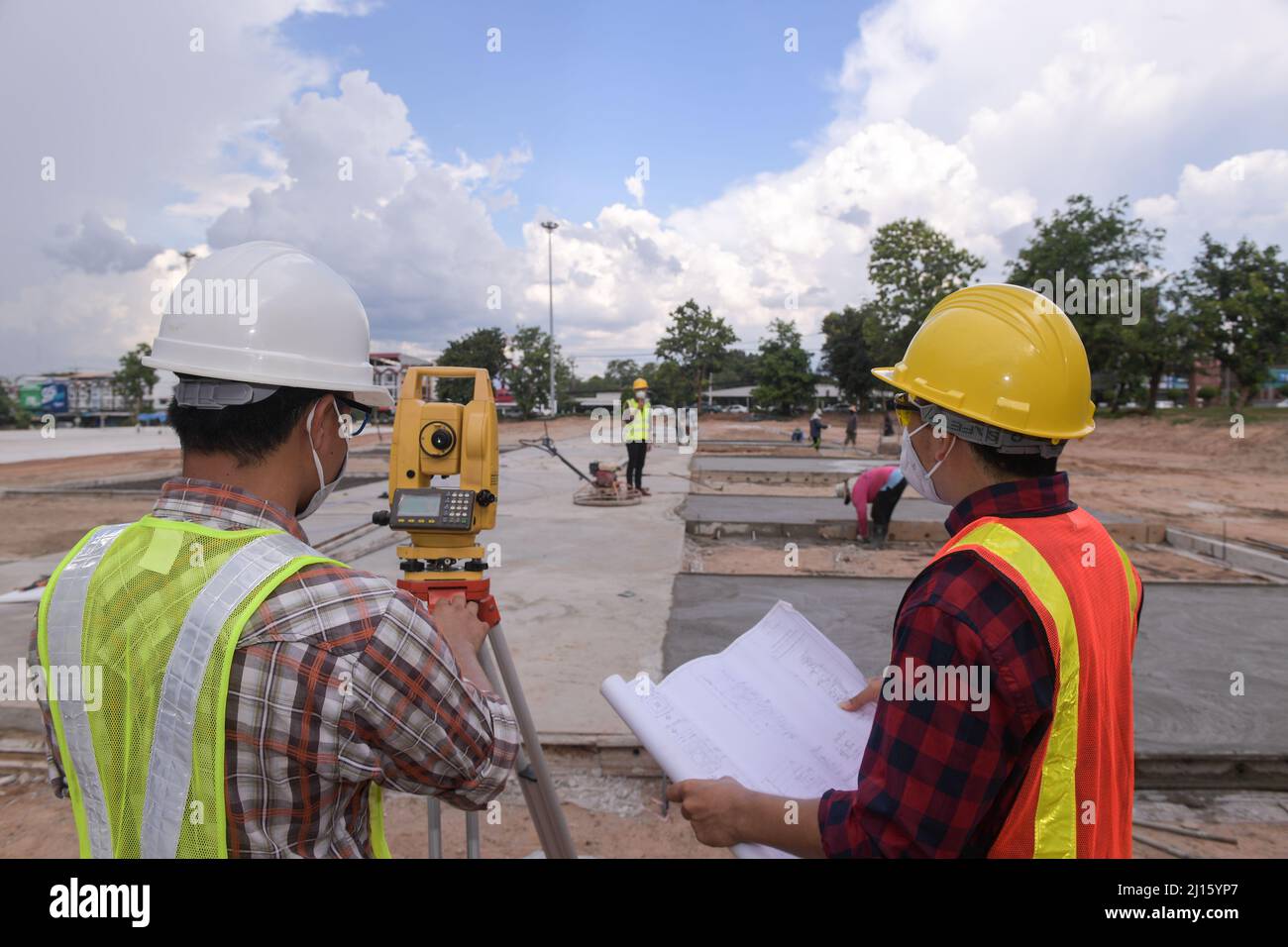 Surveyor engineer worker making measuring with theodolite on road works ...