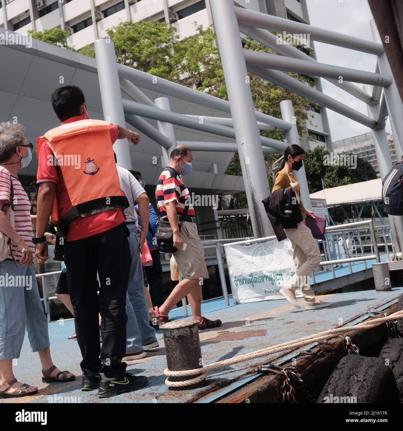 Worker on Orange Flag Express Boat Seaman Boatswain man on the ropes ...