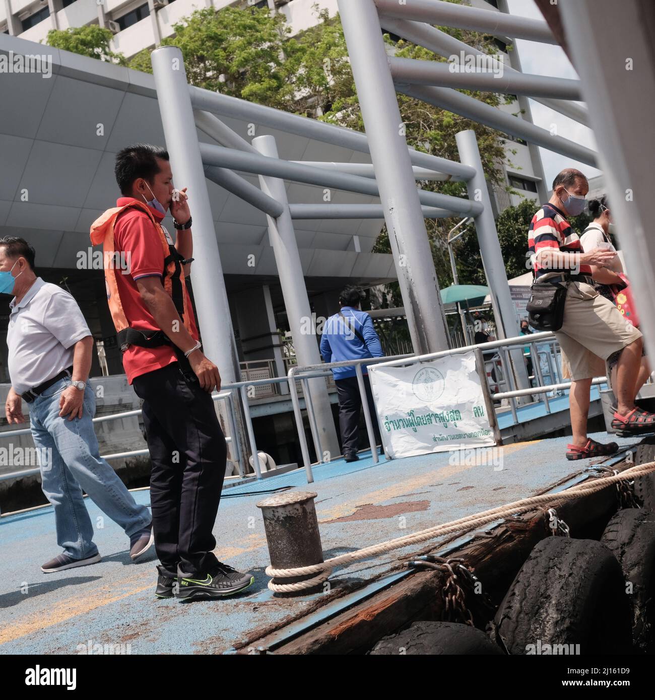 Worker on Orange Flag Express Boat Seaman Boatswain man on the ropes ...