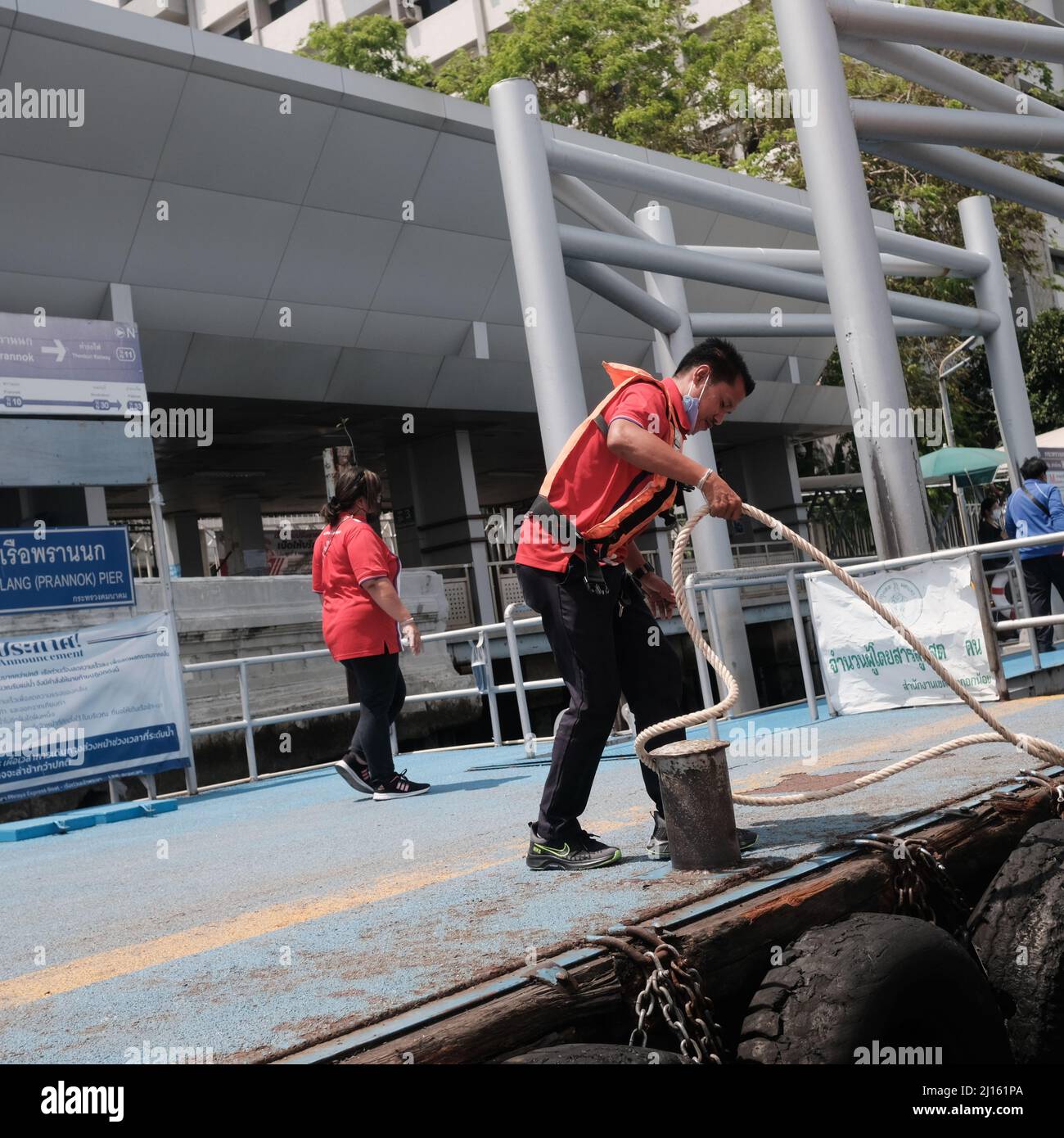 Worker on Orange Flag Express Boat Seaman Boatswain man on the ropes ...