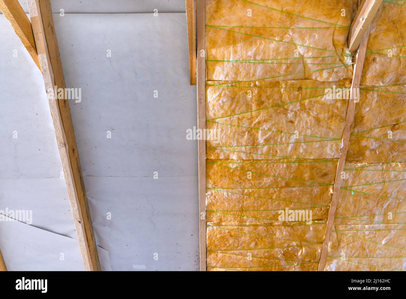 Roof before and after glass wool insulation. Laying yellow glass wool ...