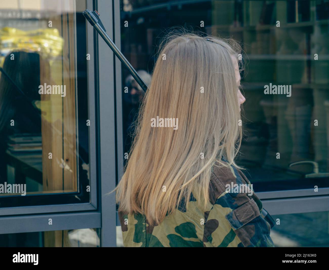 caucasian blond teen aged soldier girl on a checkpoint holding a rifle ...