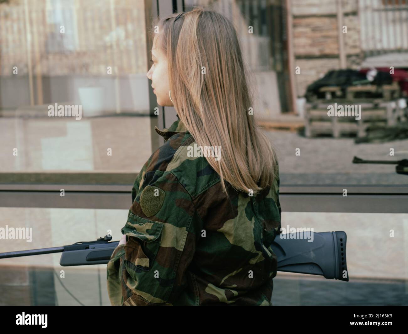caucasian blond teen aged soldier girl on a checkpoint holding a rifle ...