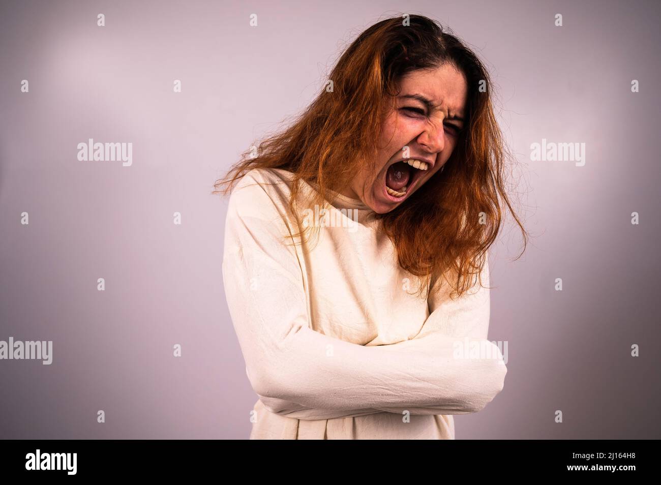 Close-up portrait of insane woman in straitjacket on white background ...