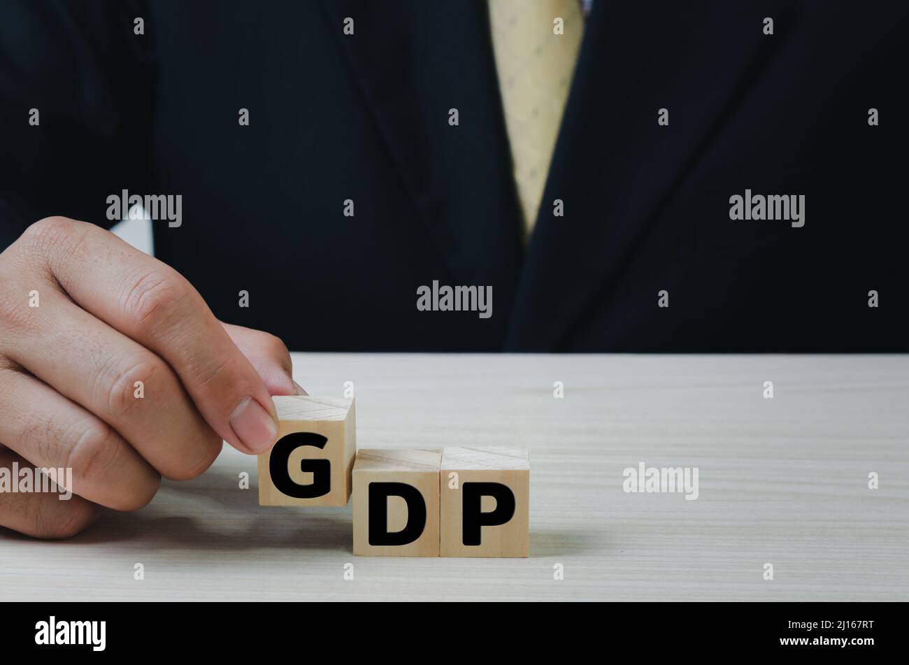 Hand put wooden cubes with GDP text Gross domestic product on table ...