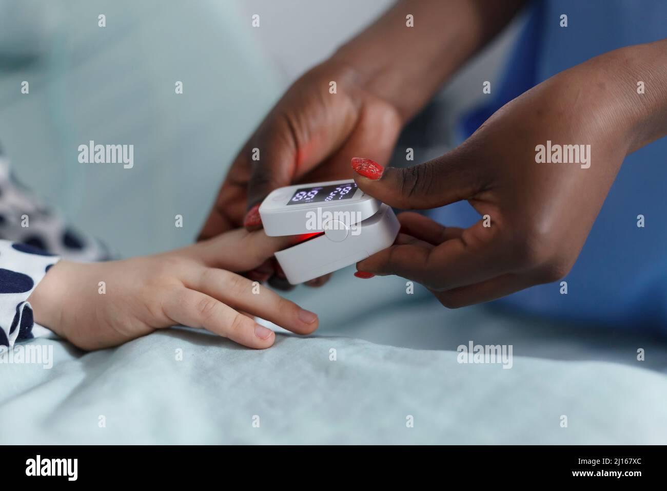 Close up of pediatric clinic nurse measuring sick child oxygen levels ...