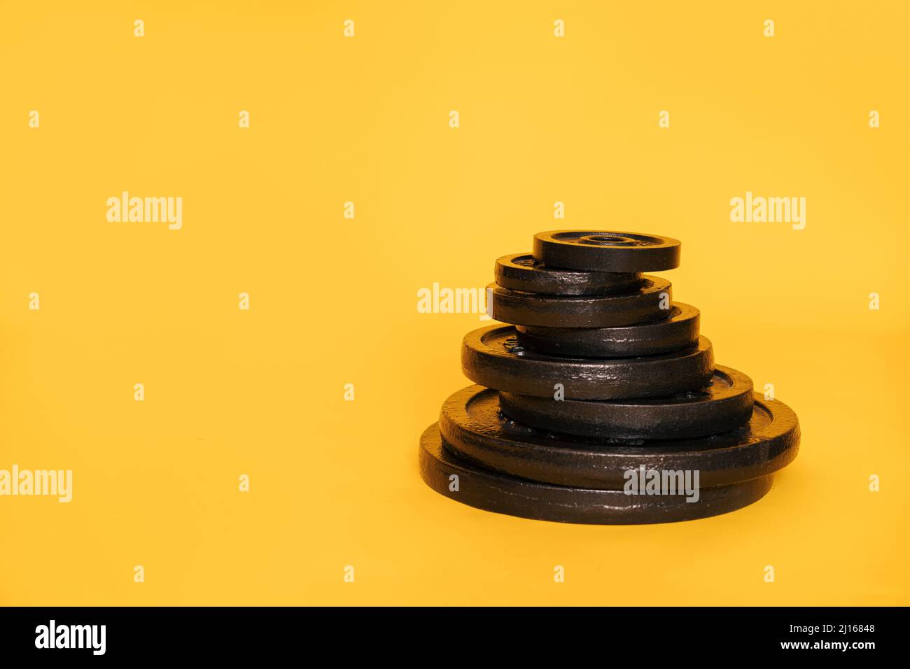 Stack of discs of different weights on yellow background Stock Photo ...