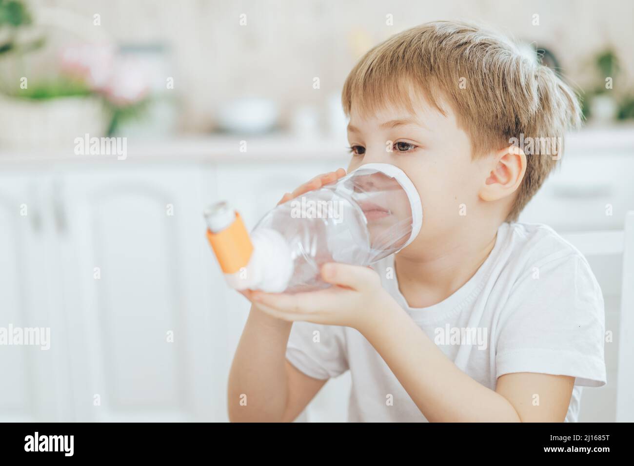 Little boy breathes with an inhaler through homemade spacer Stock Photo ...