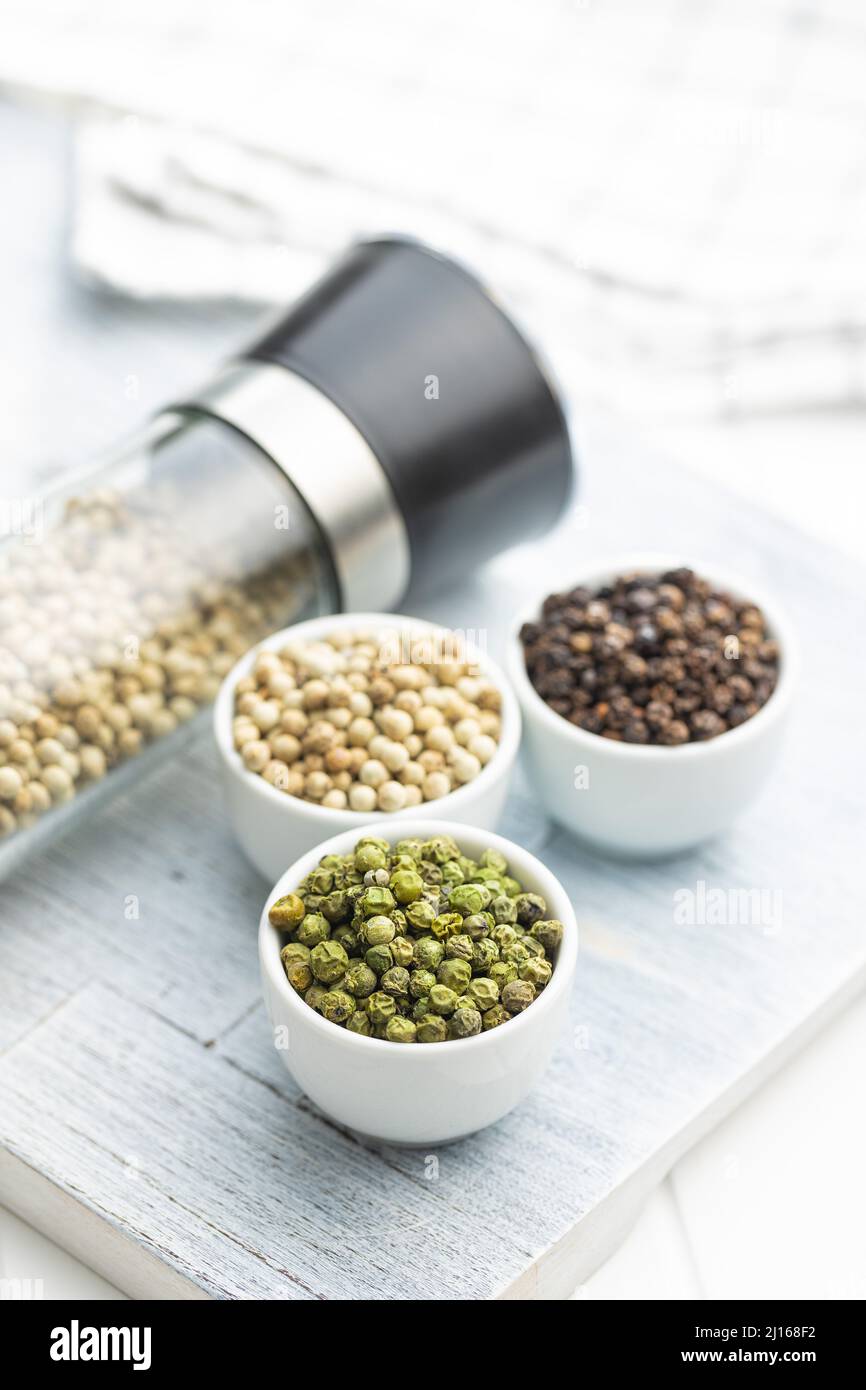 Three different types of pepper spice. Green, white and black ...