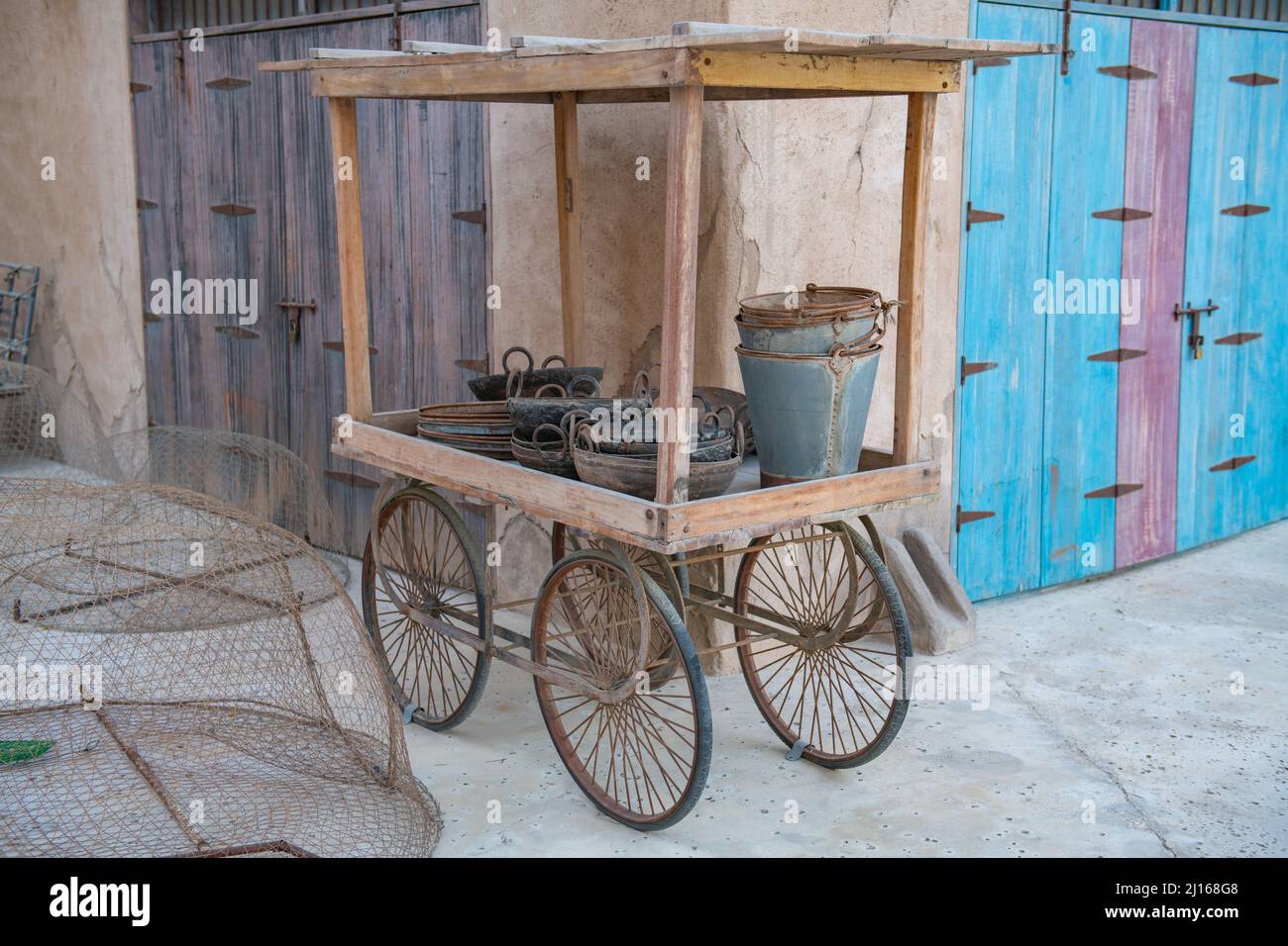 a cart with buckets stands near a house in the old town Stock Photo - Alamy