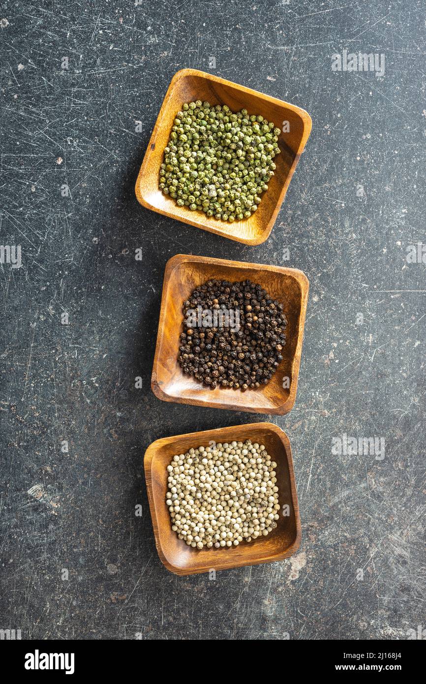 Three different types of pepper spice. Green, white and black ...