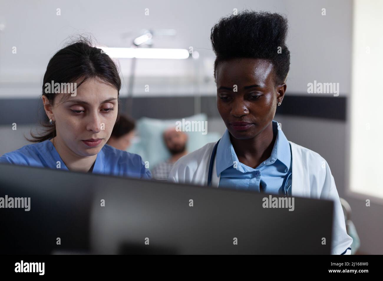 Nurse and african american doctor using personal computer for clinical ...