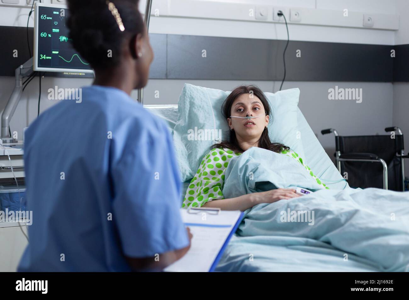 Professional nurse reading patient chart on clipboard providing medical ...