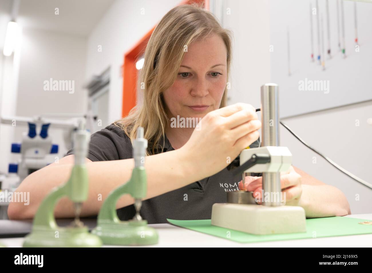 25 February 2022, Saxony, Glashütte: Sarah Westermann uses a dial gauge ...