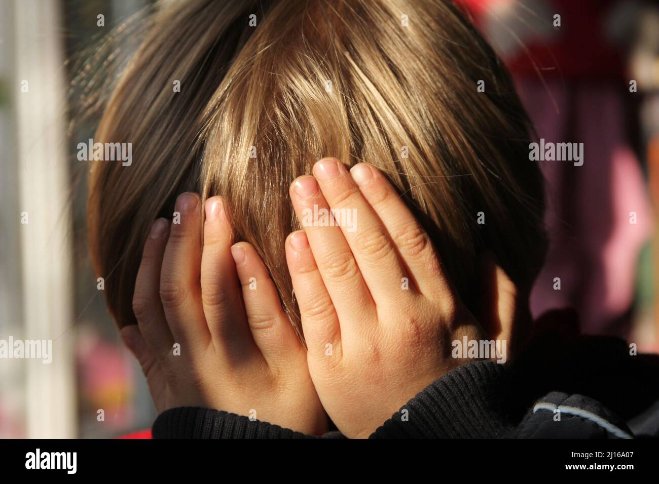 boy with blond hair covering his face Stock Photo - Alamy