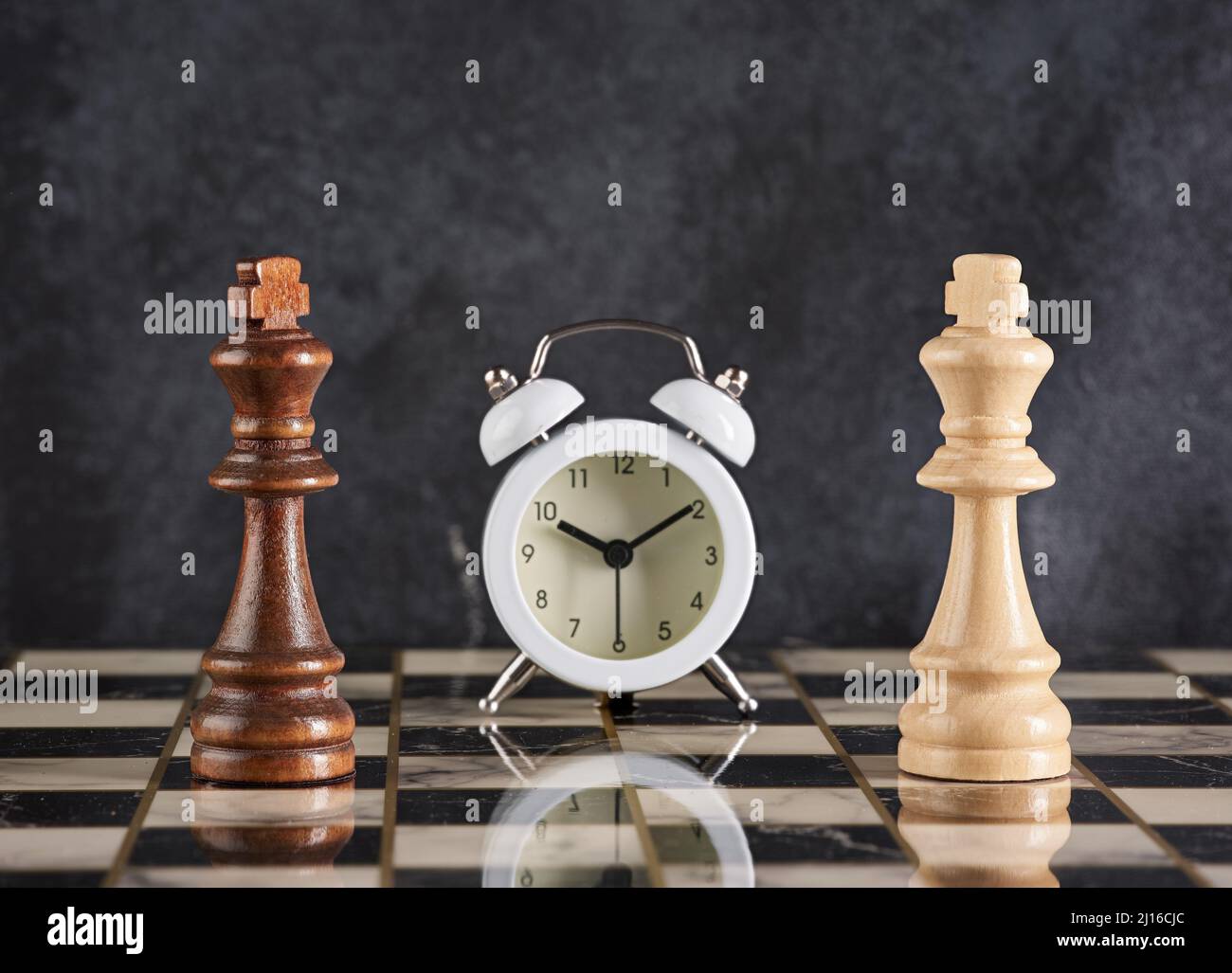 White and black king chess pieces confront each other on the chessboard ...