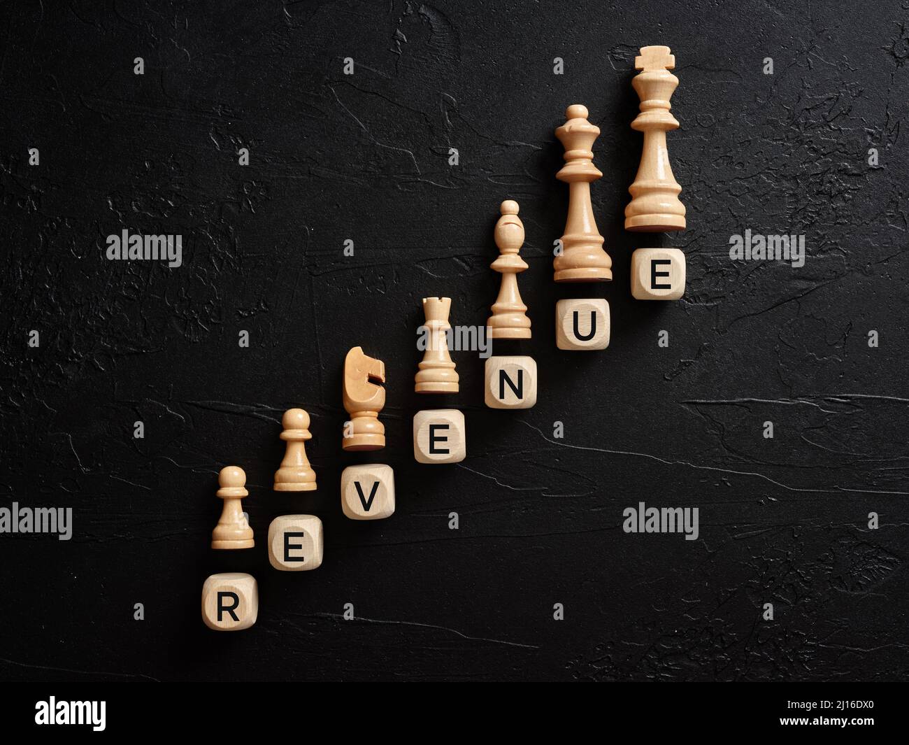 The word revenue on wooden cubes with chess pieces. Business revenue ...