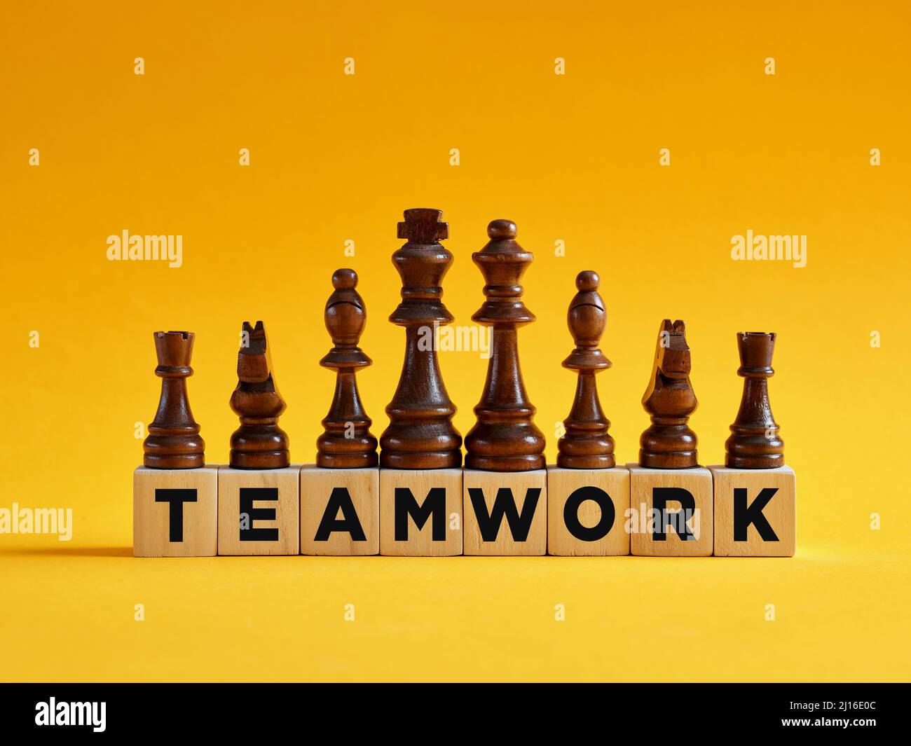 The word teamwork on wooden cubes with different chess pieces. Business ...