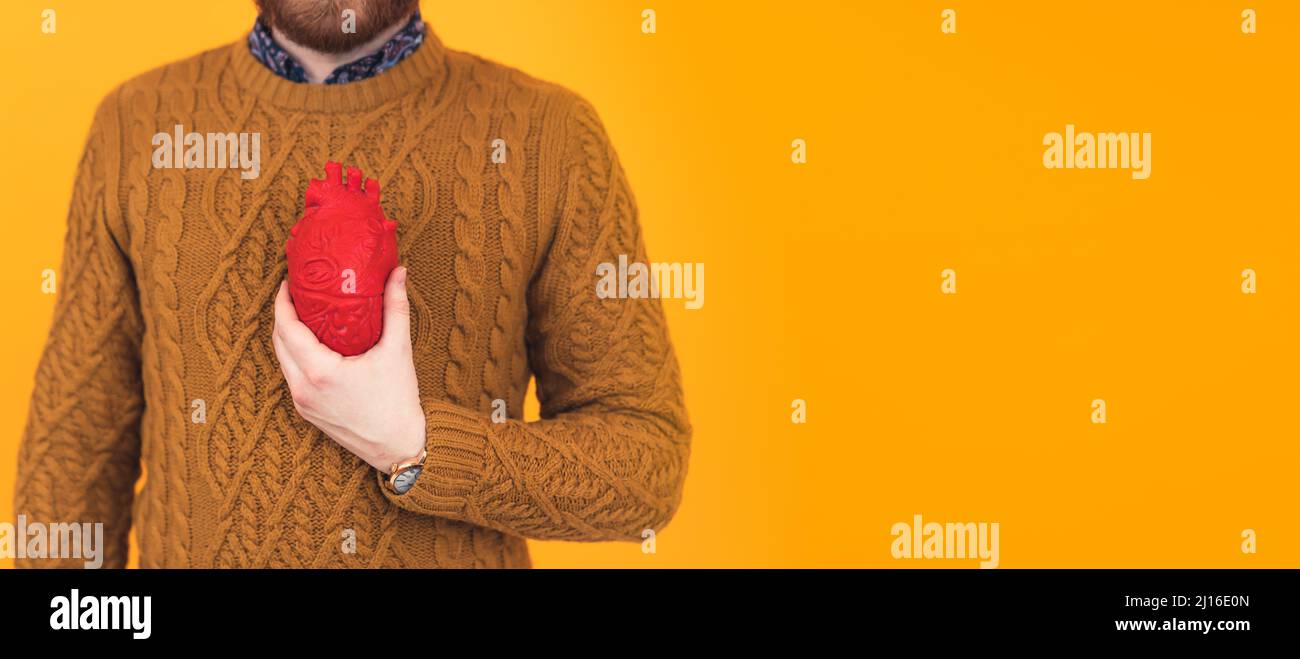 Young bearded Caucasian man holding artificial heart in his hand, the ...