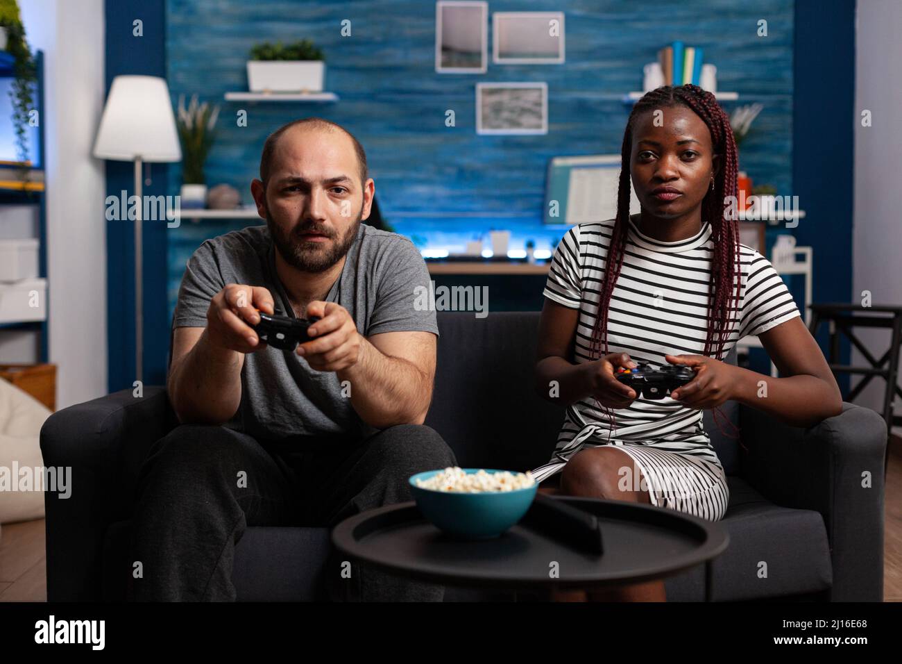Focused caucasian man playing online game against african american ...