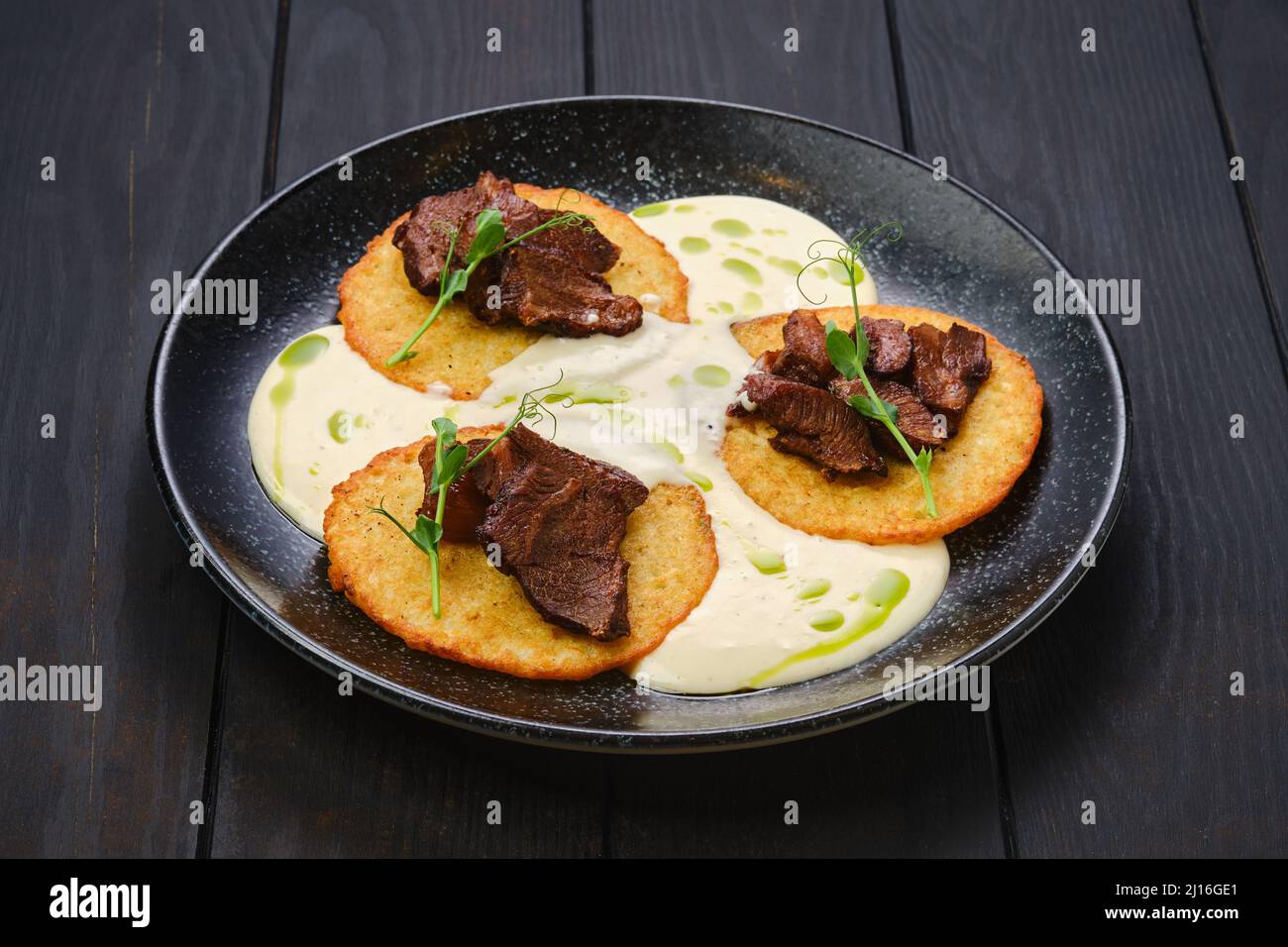 Potato fritters with with fried beef slices Stock Photo - Alamy