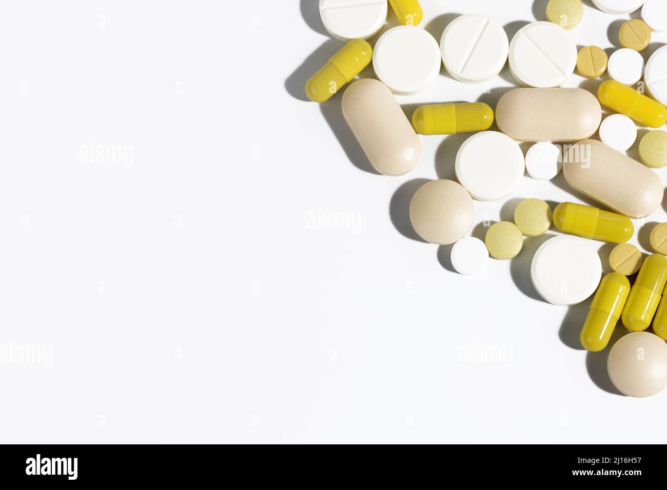 Pills and capsules of different shapes and sizes are isolated on a ...