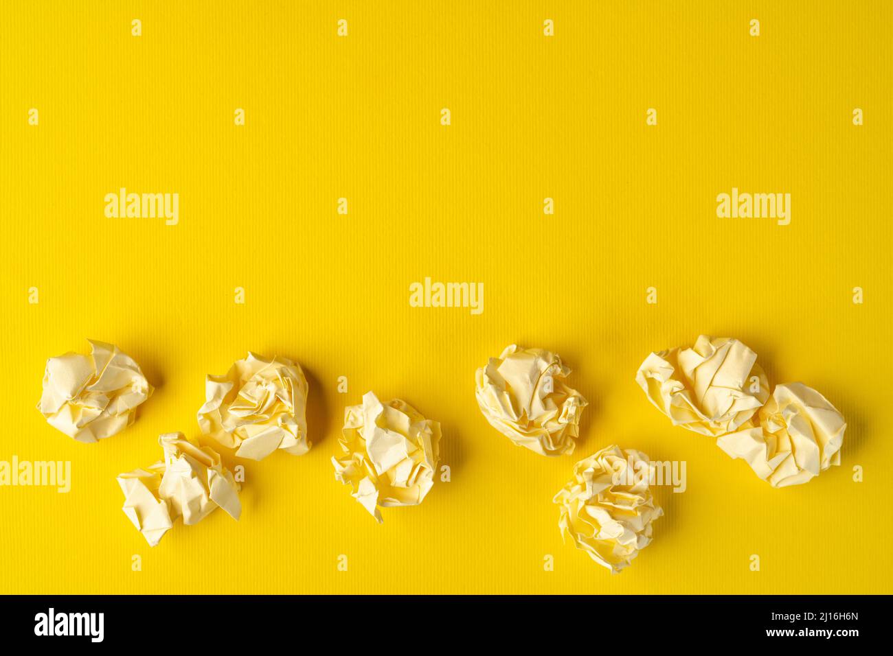 some crumpled pieces of paper on a yellow surface Stock Photo - Alamy