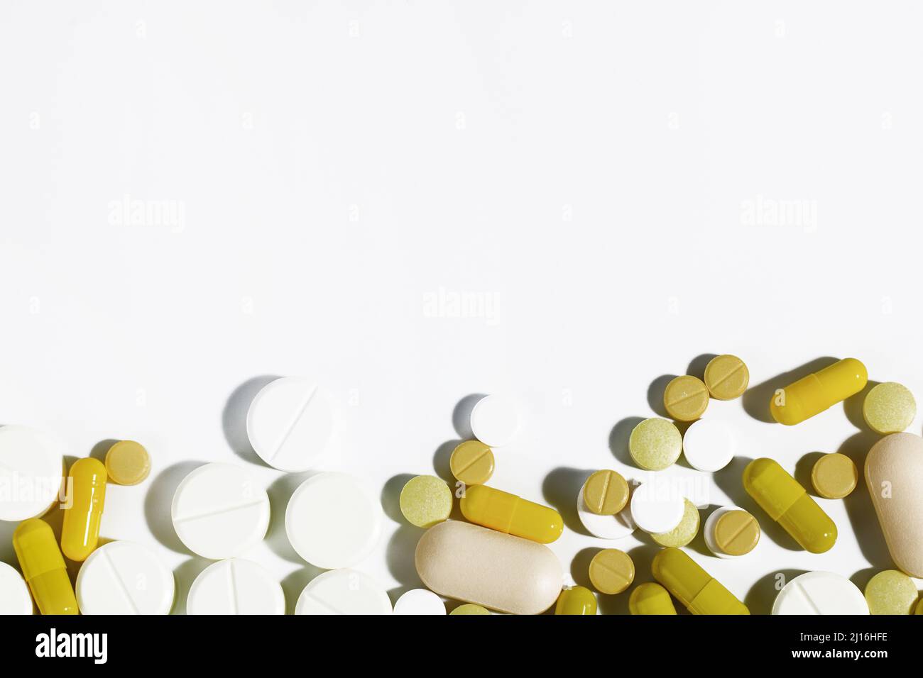 Pills and capsules of different shapes and sizes are isolated on a ...